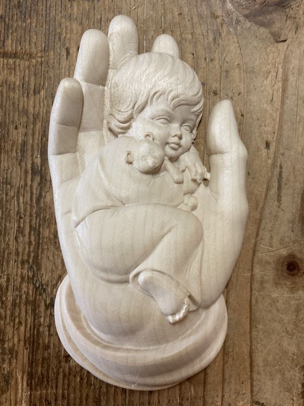 Schützende Hände aus Holz geschnitzt